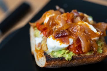 Avocado Toast with baked garlic, tomatoes and caramelized onions